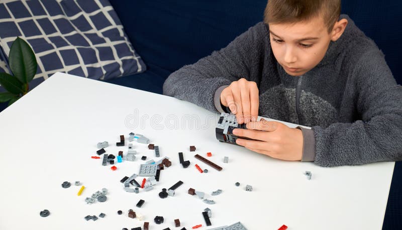Child Concentrating on Assembling Plastic Construction Bricks at Home ...