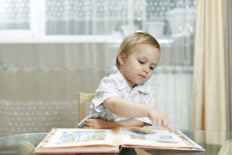 Child is Considering His First Book Stock Photo - Image of education ...