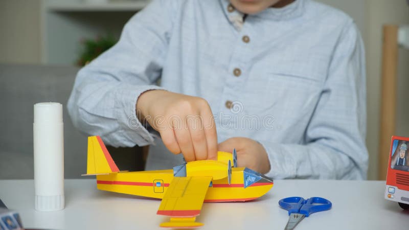 A Child Creates a Toy Airplane Using Glue and Paper Stock Video - Video ...