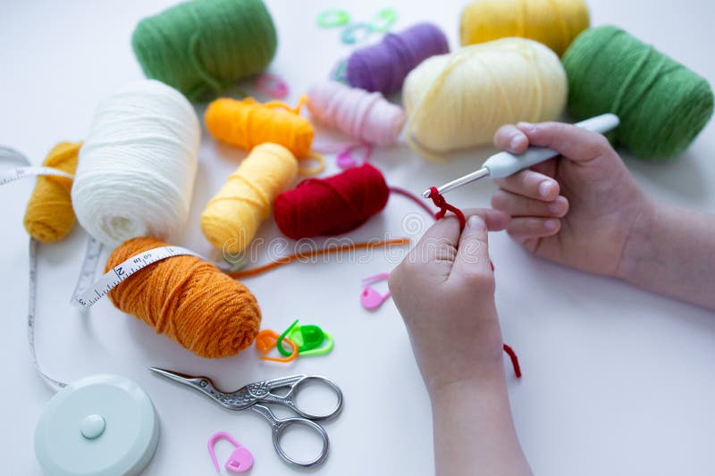 Child Crocheting with Colorful Yarn and Tools on White Surface Stock ...