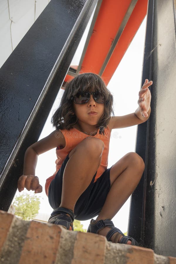 Child Crouching and Playing Inside Modern Metal Structure Stock Photo ...