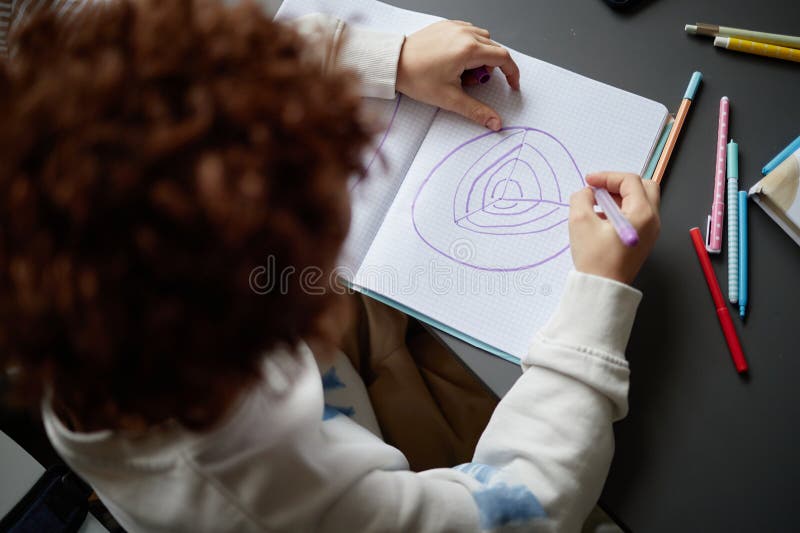 Child Drawing Layered Diagram of Planet in Notebook Using Colored ...