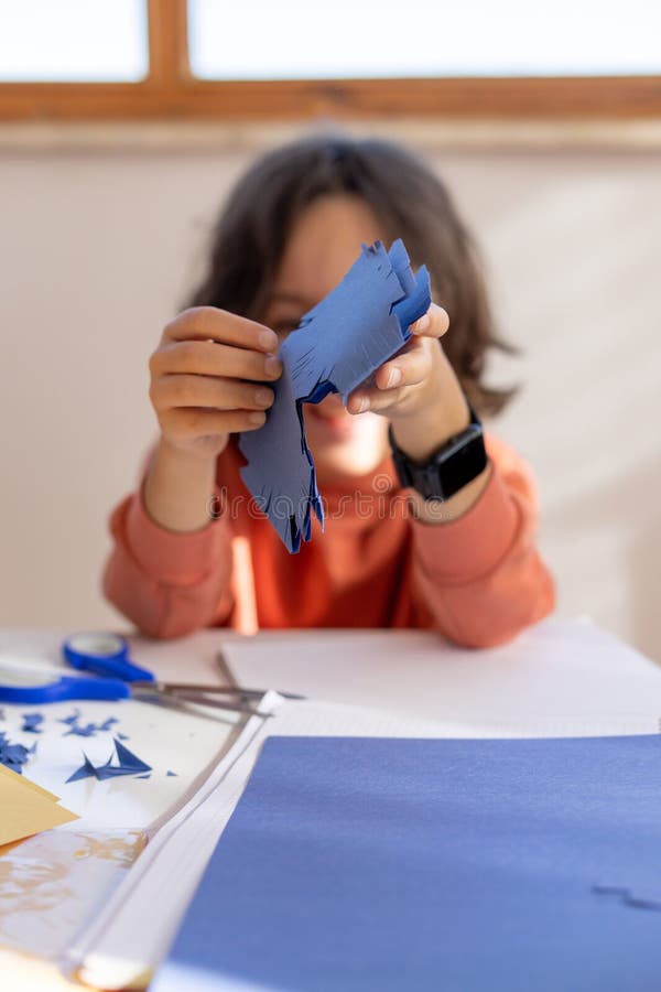 The Child Cuts Colored Paper with Scissors at the Table. the Boy Cuts a ...