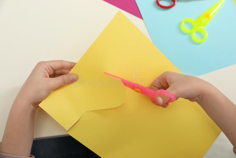 Child Cutting Color Paper with Plastic Scissors at Table Stock Photo ...