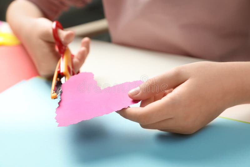 Child Cutting Out Paper Heart with Craft Scissors at Table Stock Photo ...