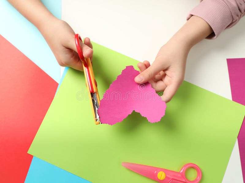 Child Cutting Out Paper Heart with Craft Scissors at Table, Top Stock ...