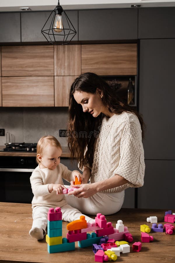 Child Daughter is Playing in Bricks Constructor with Mom Together ...