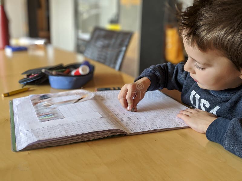 Child Doing Homework on the Kitchen Table Stock Image - Image of read ...