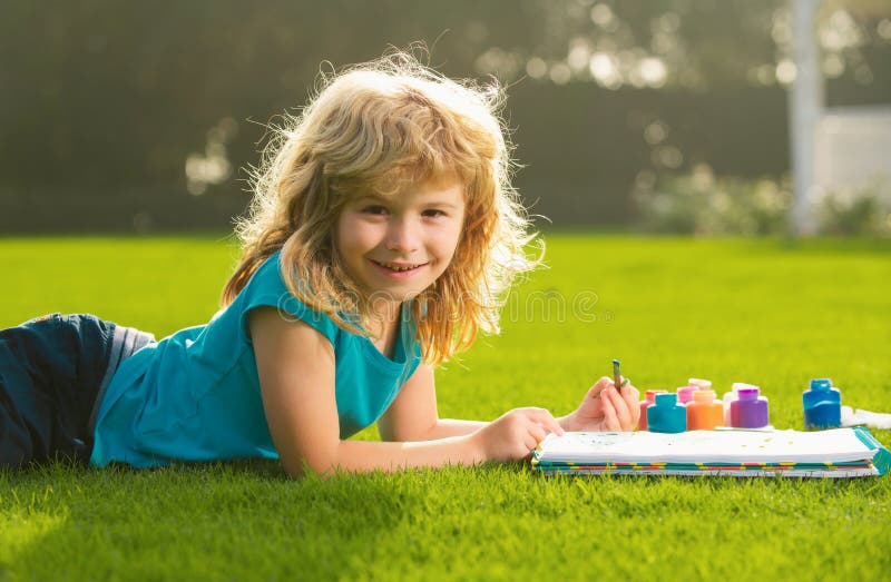 Child Drawing. Kid Draws in Park Laying in Grass Having Fun on Nature ...