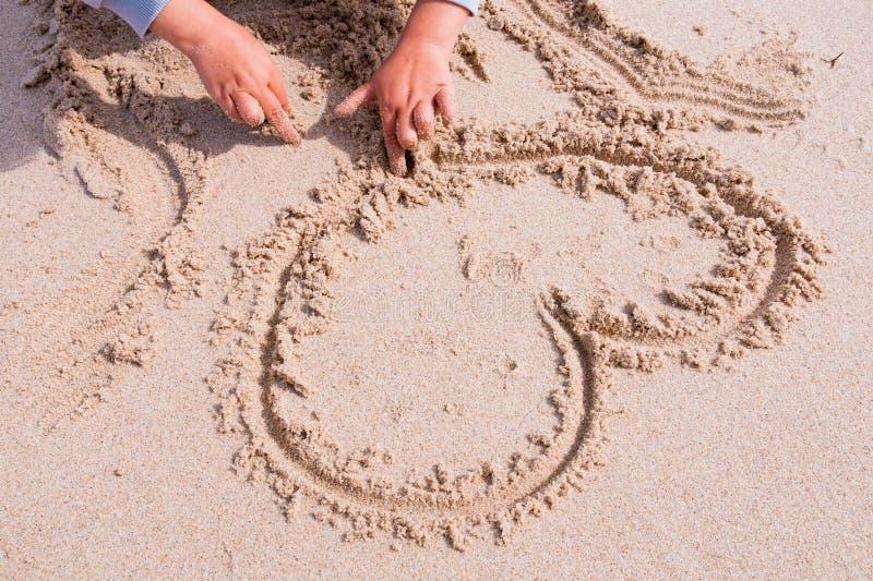 Child Drawing in Sand with Fingers on a Sunny Beach Day Stock Photo ...