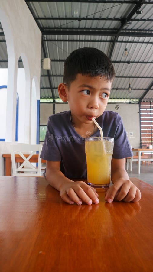 A Child Drinking at a Restaurant Stock Image - Image of play, green ...