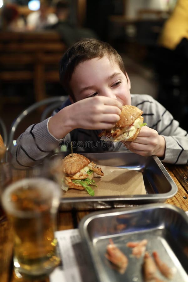 Child eating burger stock image. Image of appetite, childhood - 175319425