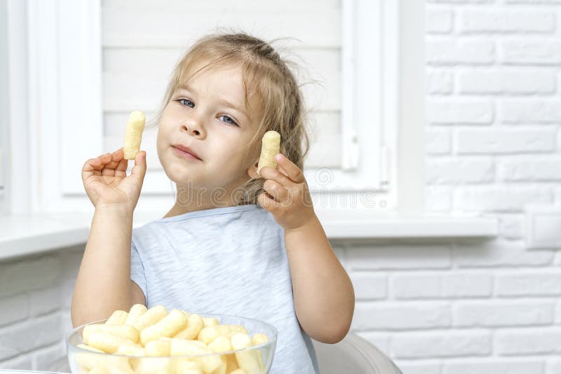 Child Eating Corn Sticks at the Kitchen Table Stock Image - Image of ...