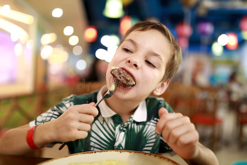 Child eating veal cutlet stock image. Image of dish - 162936109