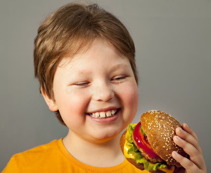 Child Eats Burger on Grey Background. Male Child with Hamburger Stock ...