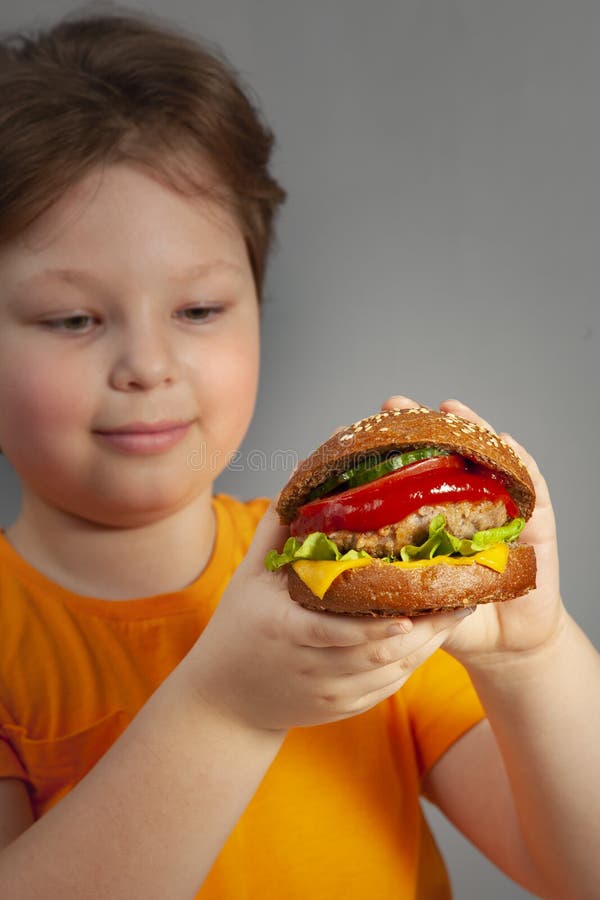 Child Eats Burger on Grey Background. Male Child with Hamburger Stock ...
