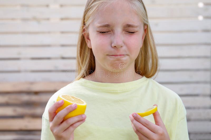 The Child Eats a Sour Lemon. the Girl Wrinkled Her Face Stock Image ...