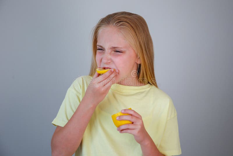 The Child Eats a Sour Lemon. the Girl Wrinkled Her Face Stock Image ...