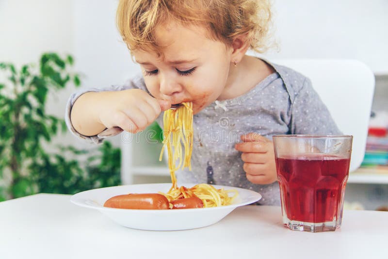 The Child Eats Spaghetti Lunch. Selective Focus Stock Photo - Image of ...