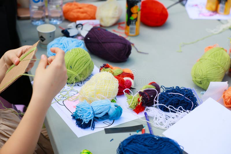 Child Engaged in Colorful Yarn Craft Project at Creative Workshop. May 31, 2024 Balti Moldova ...