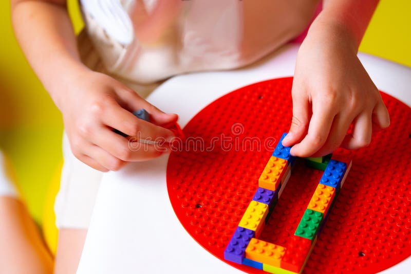 Child Engaged in Creative Play with Colorful Building Blocks on a Round ...