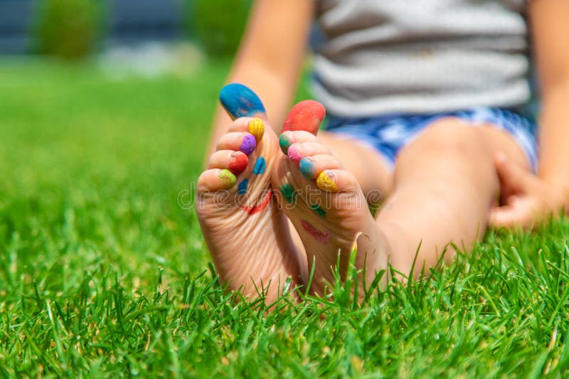 Child Feet Drawing Smile in the Park on the Grass. Selective Focus ...