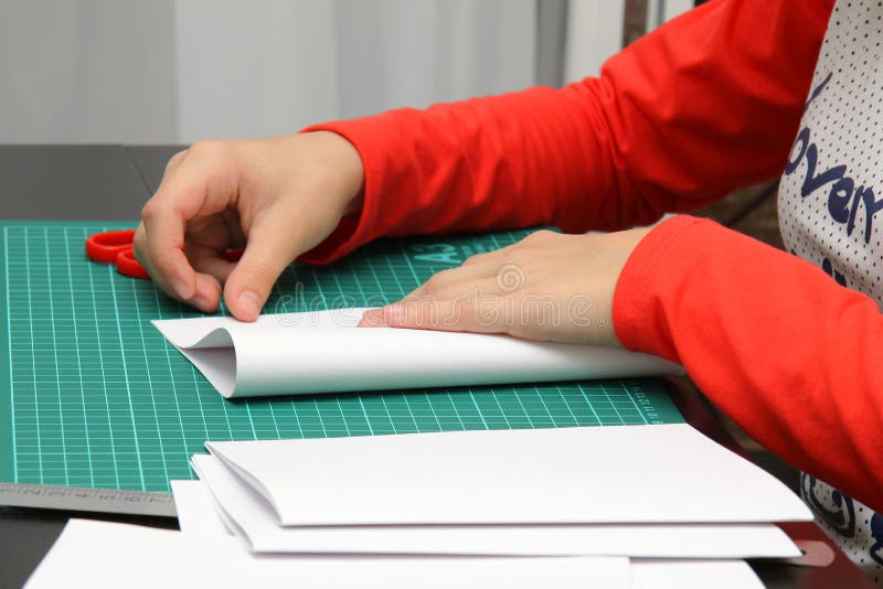 The Child Folds Sheets of Paper for Making a Notebook Stock Image ...