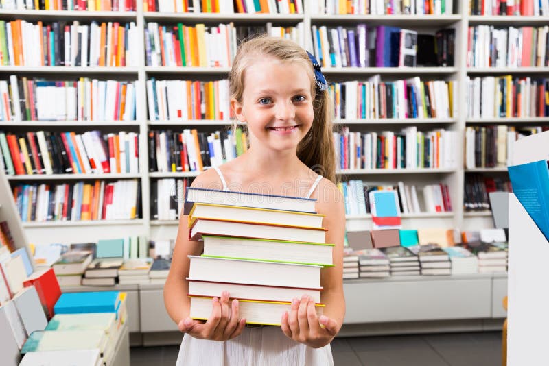 Child Girl Holding a Stack of Books in a Bookstore Stock Photo - Image ...
