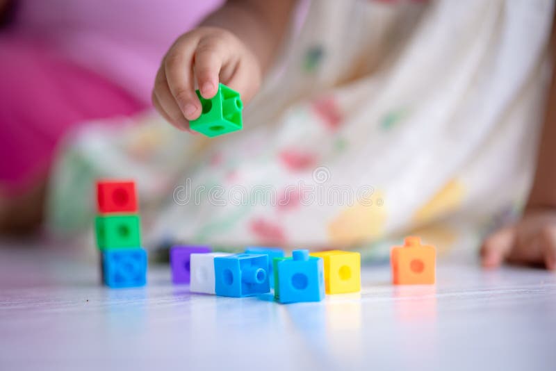 Child Girl is Using Hands Assembling Colored Cubes Stock Image - Image ...