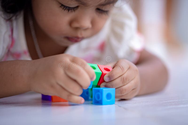 Child Girl is Using Hands Assembling Colored Cubes Stock Photo - Image ...