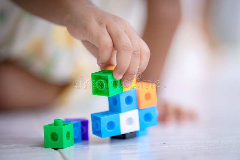 Child Girl is Using Hands Assembling Colored Cubes Stock Image - Image ...
