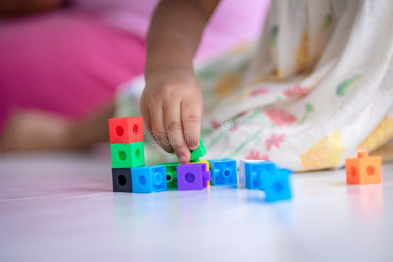Child Girl is Using Hands Assembling Colored Cubes Stock Photo - Image ...
