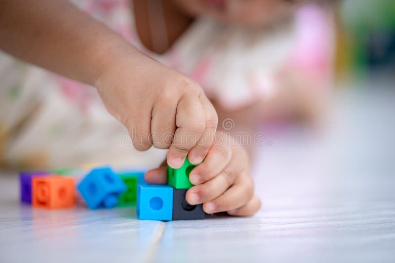 Child Girl is Using Hands Assembling Colored Cubes Stock Photo - Image ...