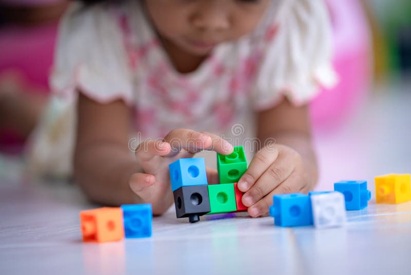 Child Girl is Using Hands Assembling Colored Cubes Stock Photo - Image ...