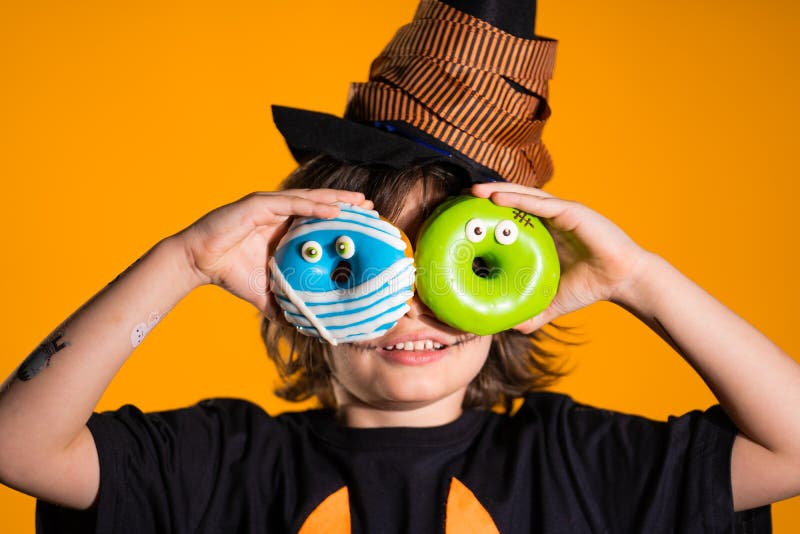 Child with Halloween Donut Doing Poses on Orange Background Stock Image ...