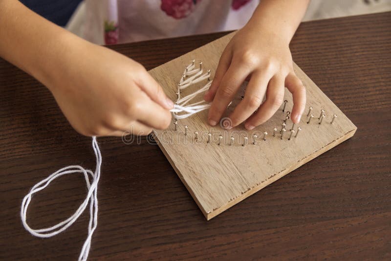 Child Hands Creating String Art on Wood. Developing Fine Motor Skills ...