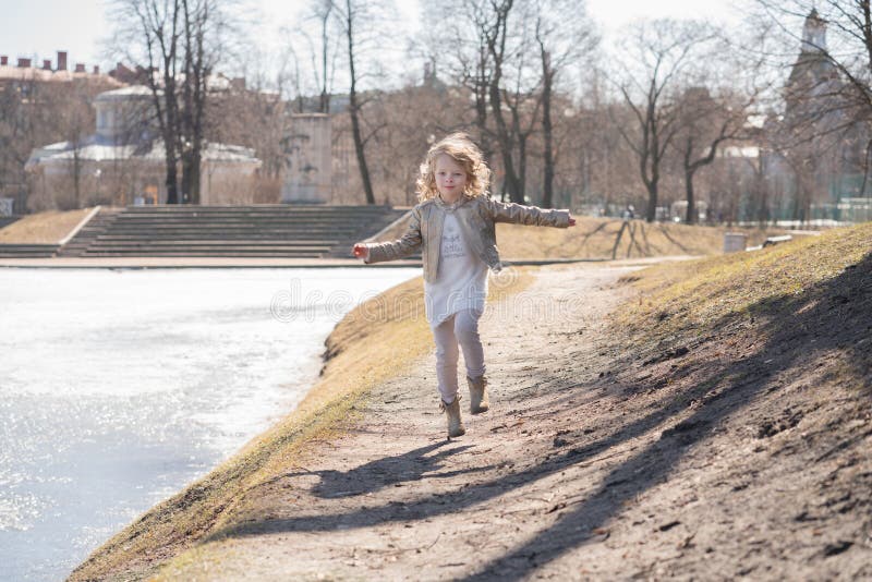 Child Happy Jumping and Running in the Cold Spring City Park Alone ...