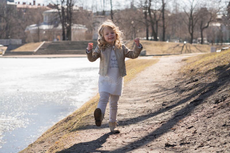 Child Happy Jumping and Running in the Cold Spring City Park Alone ...