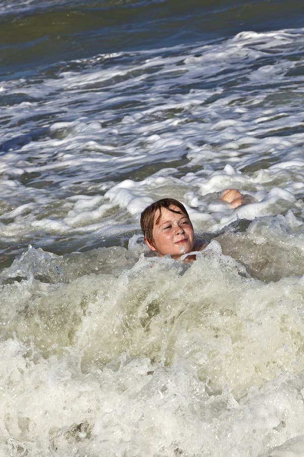 Child has fun in the waves stock photo. Image of brown - 62723490