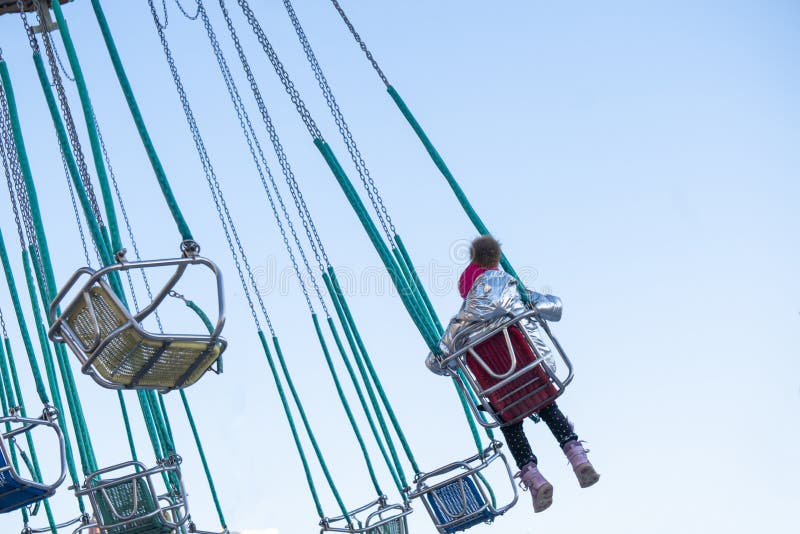 Child Having Fun Riding on a Chain Carousel in the Amusement Park B ...