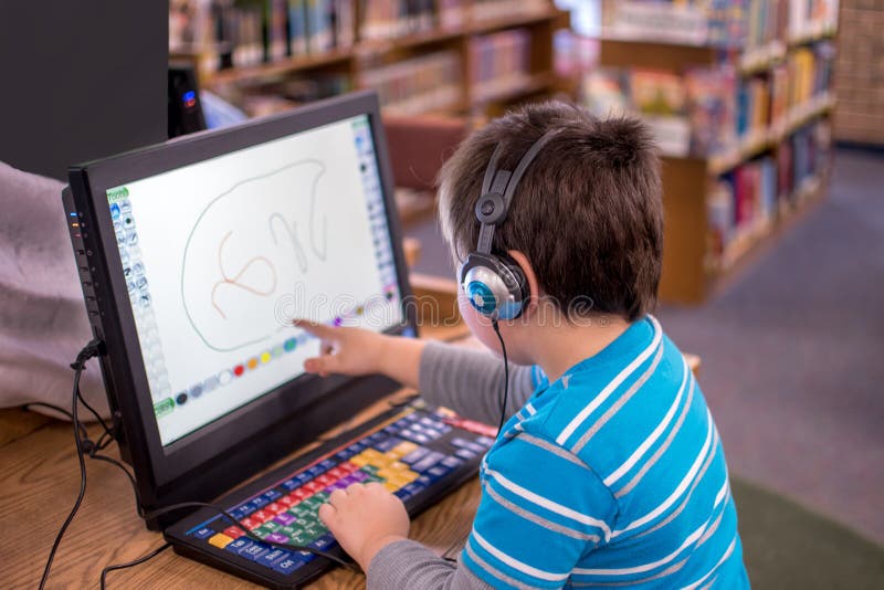 A Child Works an Interactive Game on a Laptop at the Library Editorial ...
