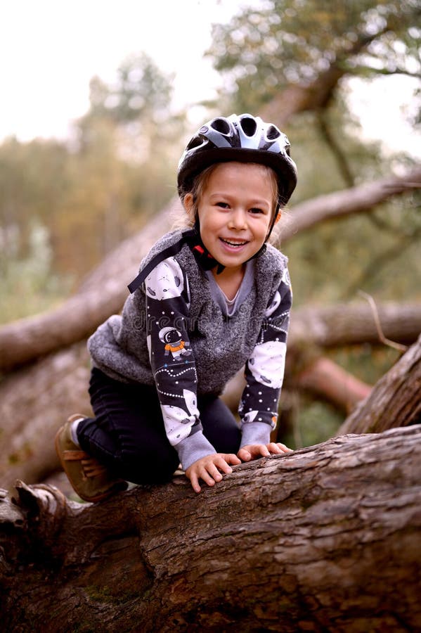 A Child in a Helmet Climbing a Tree Stock Image - Image of safety, park ...