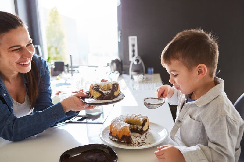 Child helps mother bake a cake in the kitchen