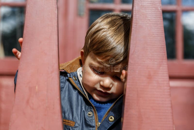A Child is Hiding Behind Two Wooden Bars Stock Image - Image of ...