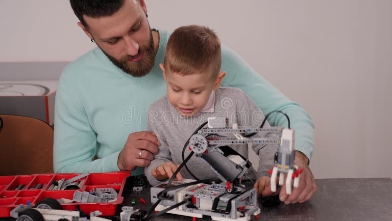 A Child and His Father Playing with a Robot Assembled from a ...