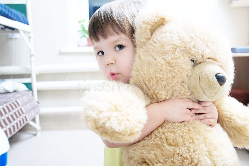 Child hugging teddy bear stock image. Image of playing - 86112725