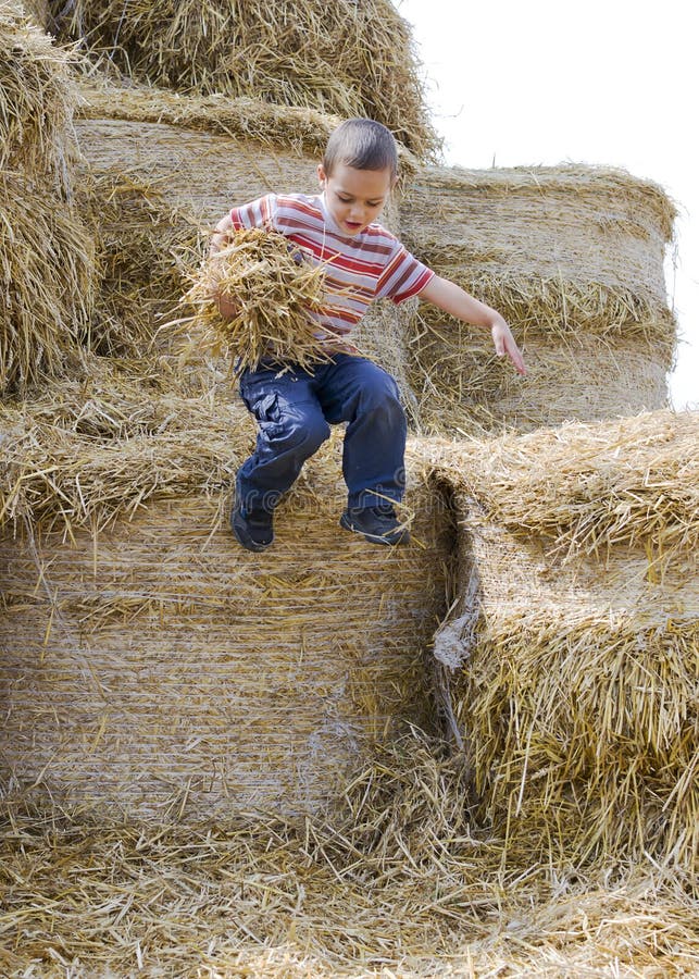 Child jumping in haystack stock photo. Image of trowing - 58292524