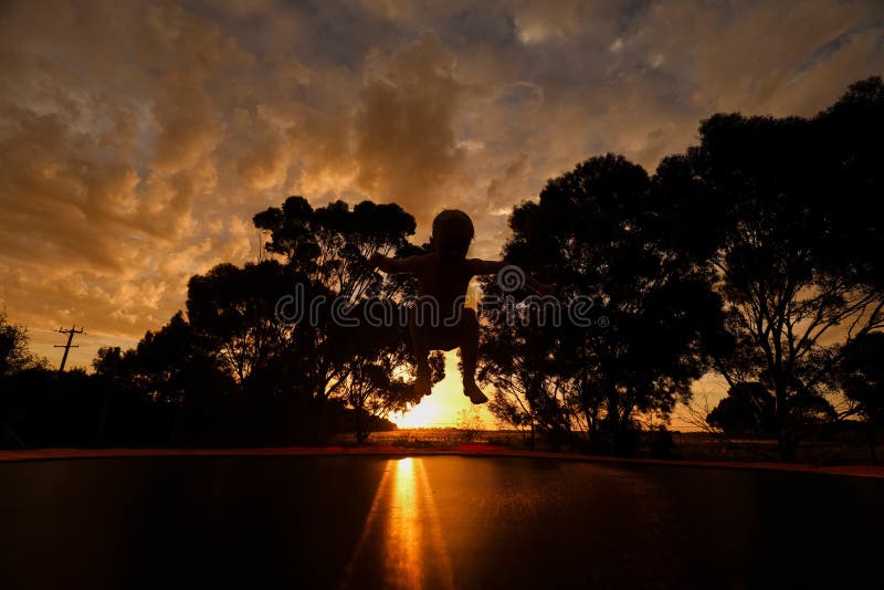 Child Jumping into a Lake at Sunset Stock Image - Image of sunset ...