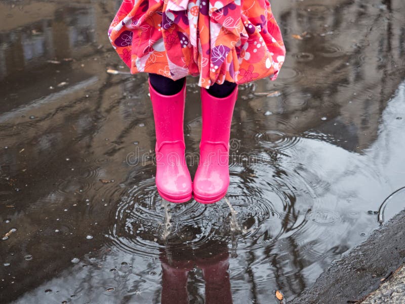 Child jumping in a puddle stock image. Image of child - 53483879