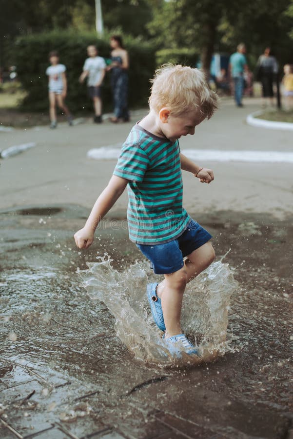 Little Boy Jumping in a Puddle in Summer Stock Image - Image of color ...